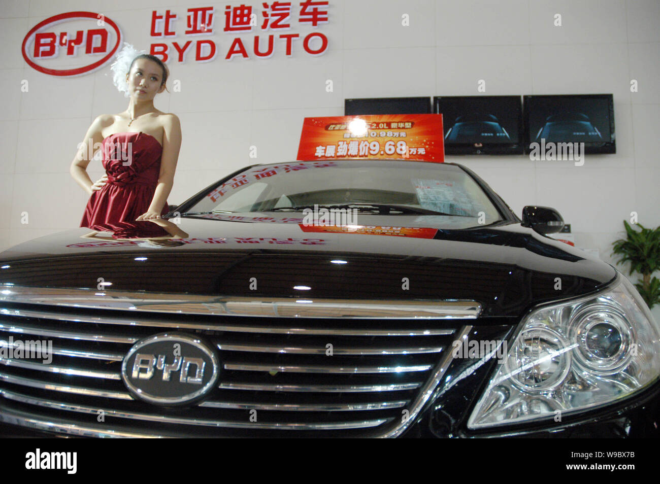 --FILE-- A model poses by a BYD car during an auto show in Fuzhou ...