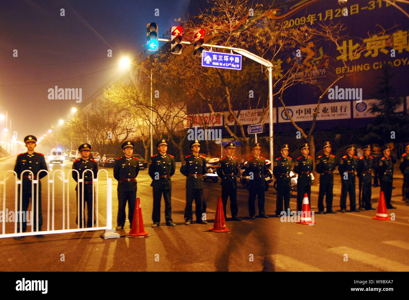 Chinese paramilitary policemen stand guard after blocking the street ...