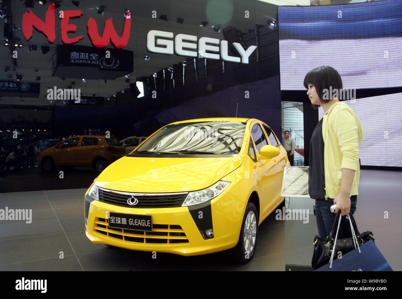 --FILE--A Chinese visitor walks past a Geely Gleagle car on display at ...