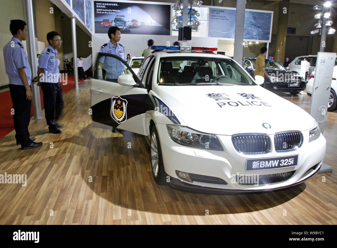 Chinese police officers look at a BMW 325i police car on display at the ...