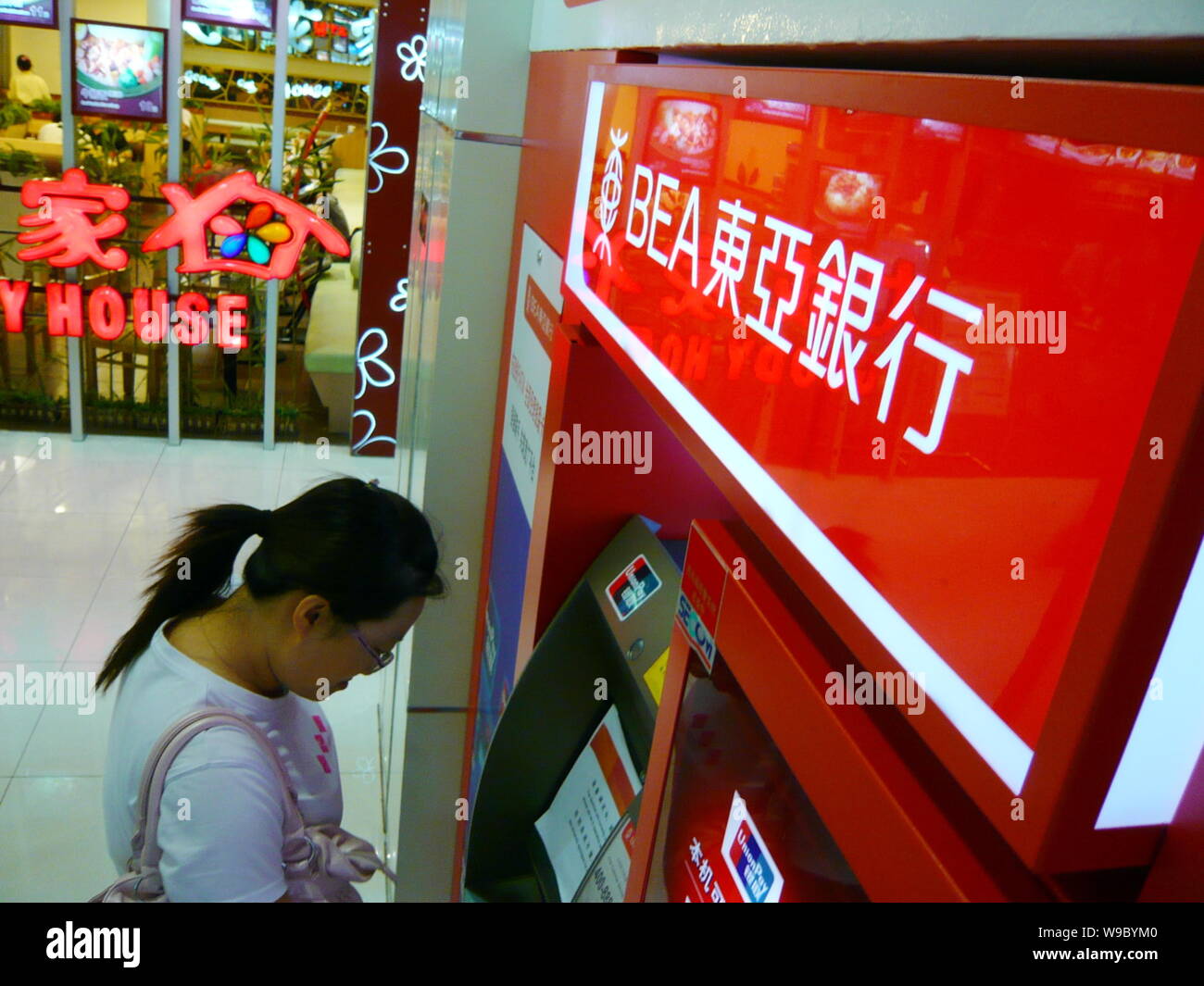 --FILE--A Chinese woman draws money from an ATM of BEA (Bank of East ...