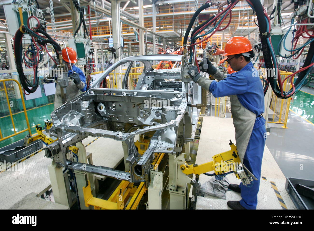 --FILE--Chinese factory workers assemble a car on the production line ...