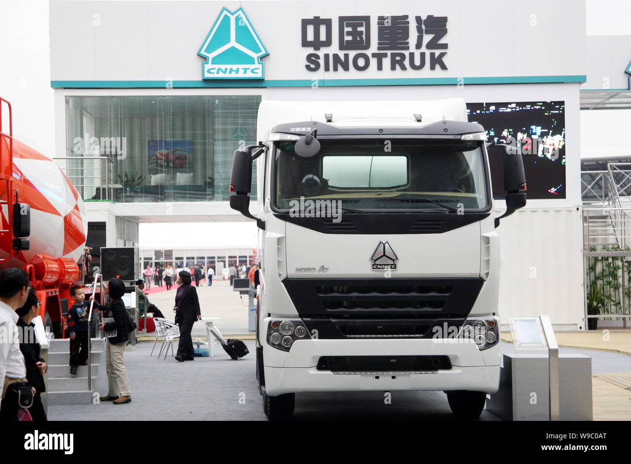 --FILE--Visitors look at a heavy duty truck at the stand of China ...
