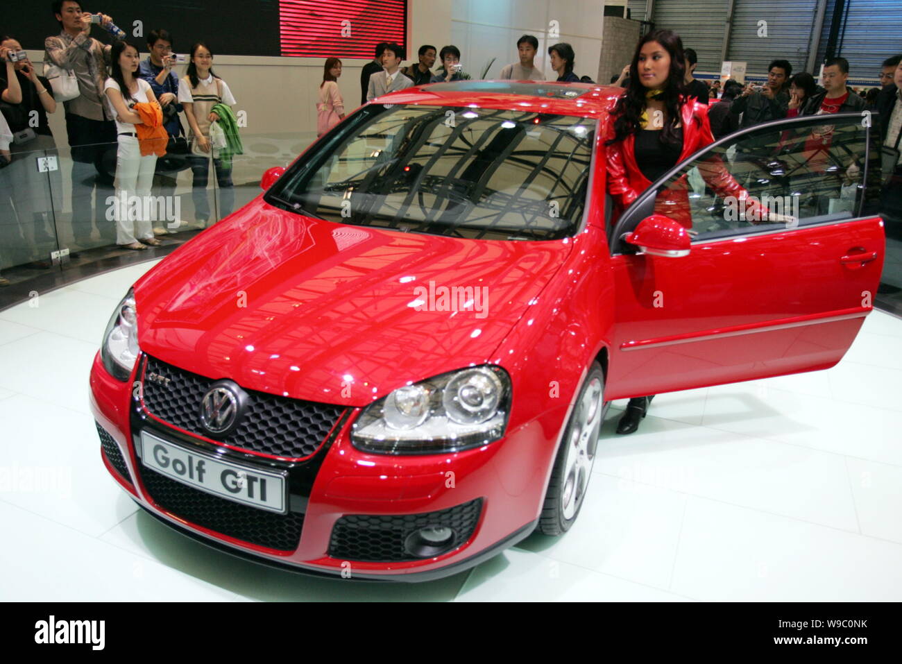 --FILE--Chinese visitors look at a Volkswagen Golf GTI on display at ...