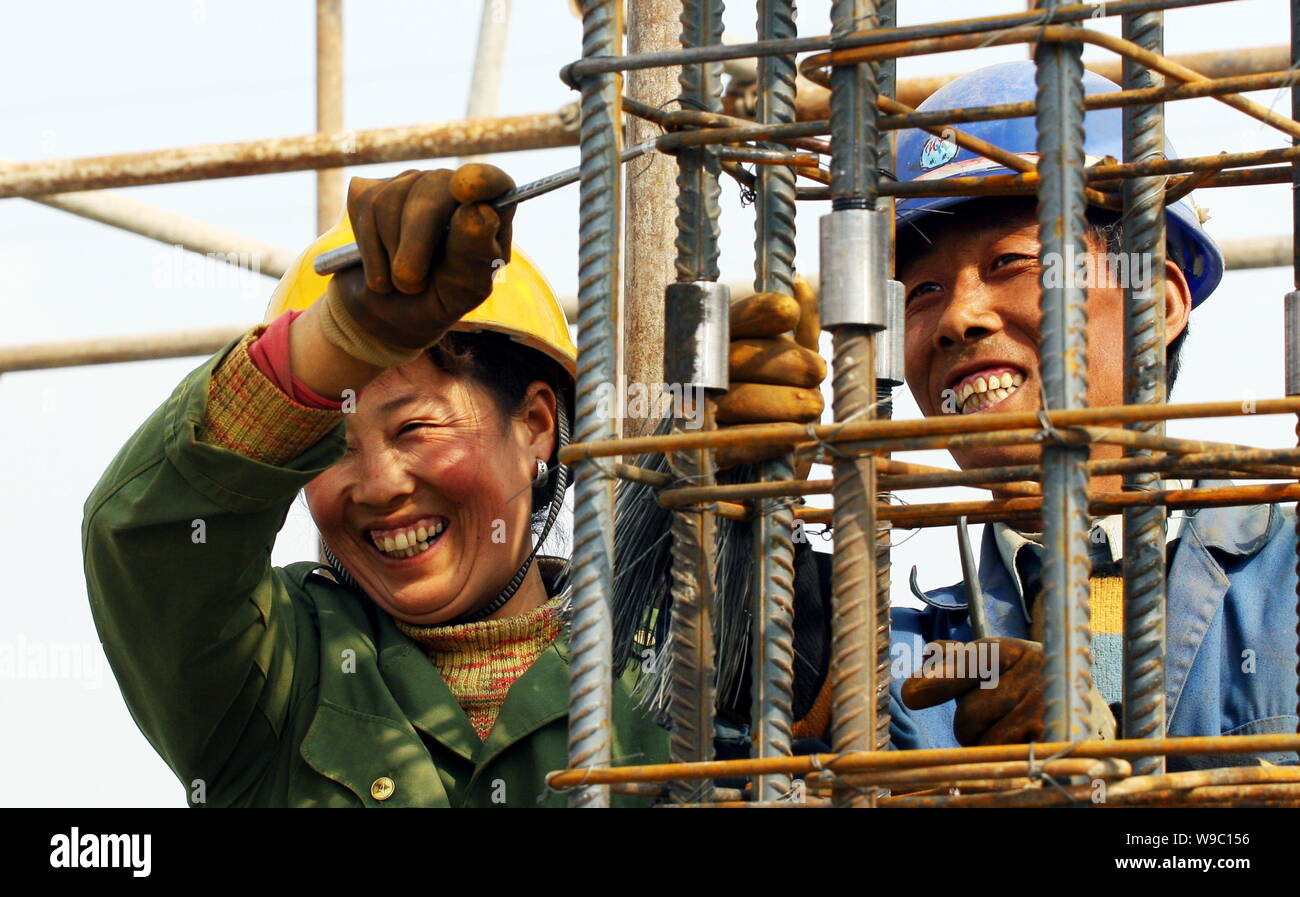 --FILE--Chinese workers tighten reinforcing steel rods at a ...