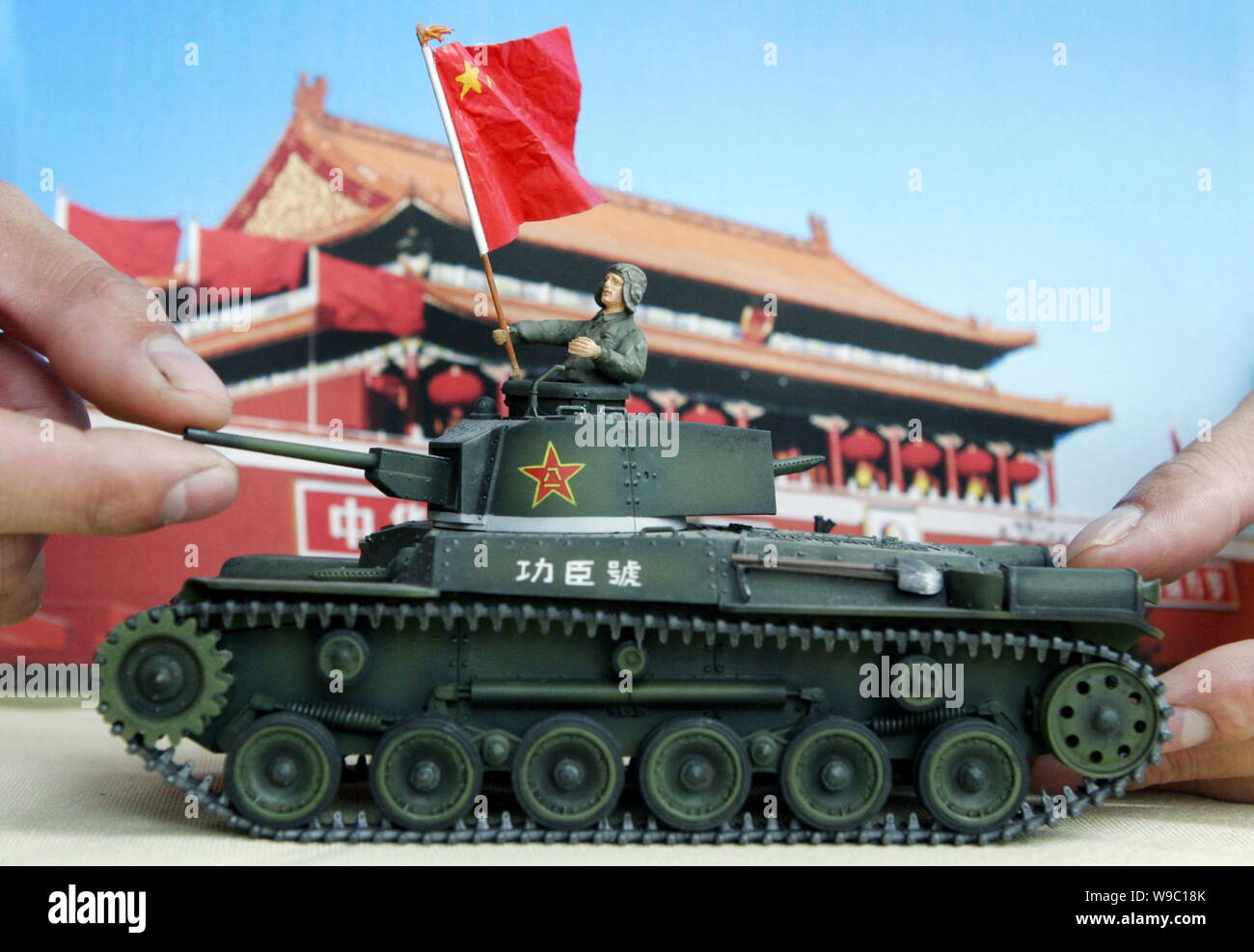 A Chinese man lines up a model tank during a model exhibition of ...