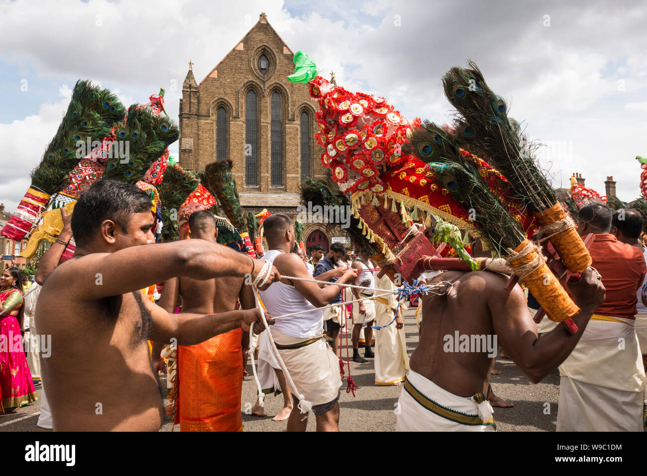 Devotees with hooks piercing their backs performing Kavadi Aattam ...