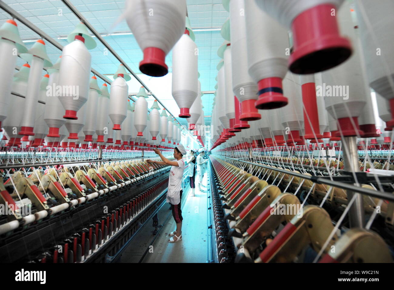 --FILE--Female Chinese factory workers check yarn spindles on spinning ...