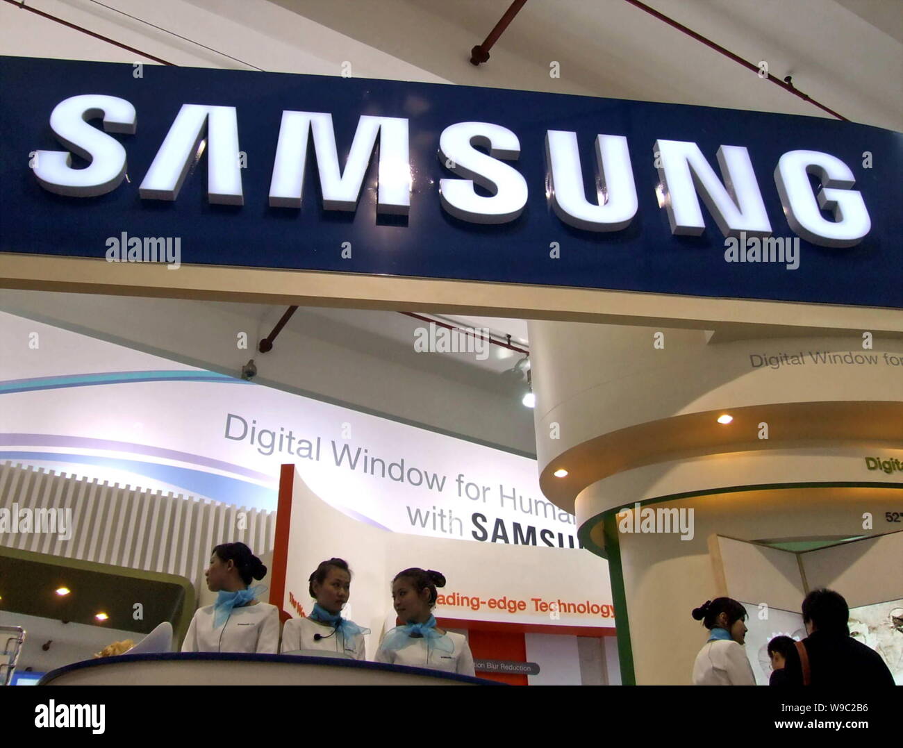 --FILE--Chinese visitors and staff are seen at the stand of Samsung ...
