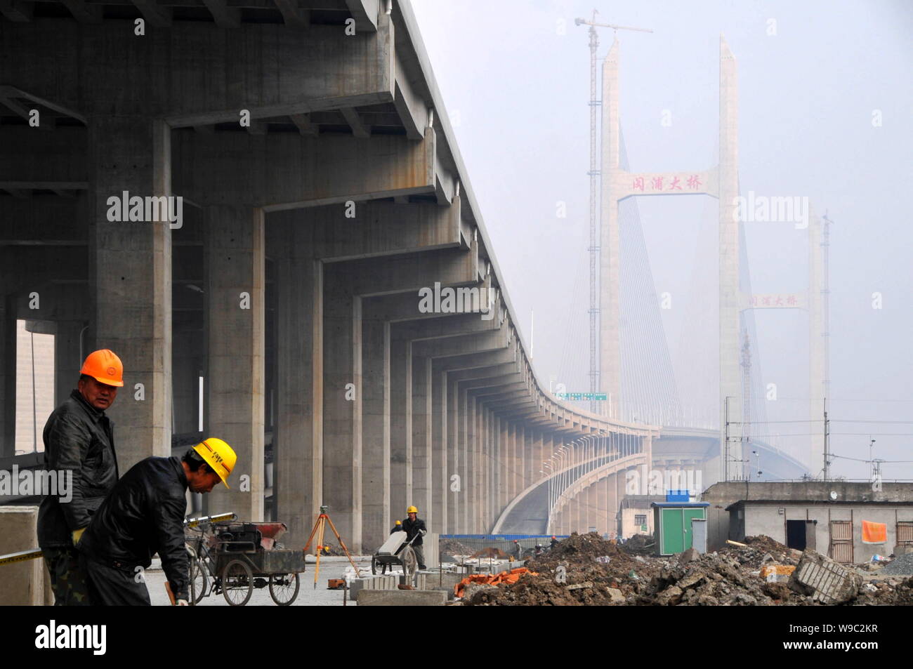 Chinese workers check and put final touches on the Minpu Bridge in ...