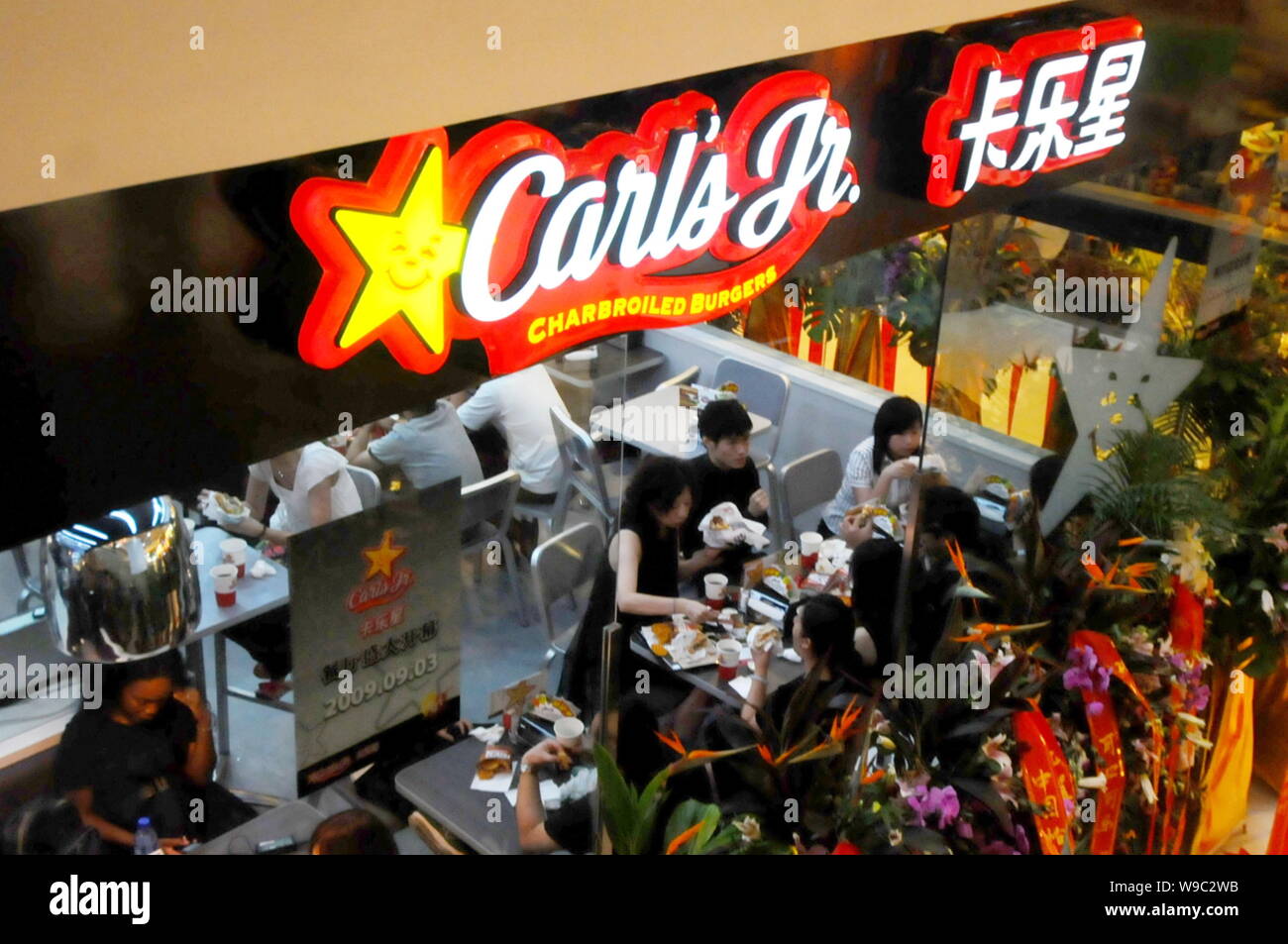 Customers eat food at a Carls Jr. restaurant in the Raffles City Mall ...