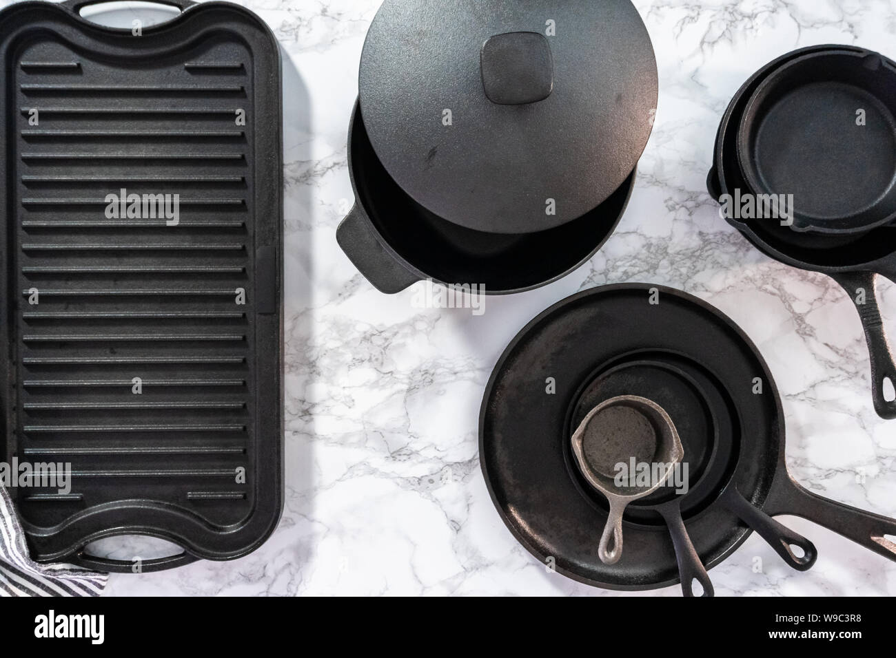 Flat lay. Variety of cast iron frying pans on a marble background Stock ...