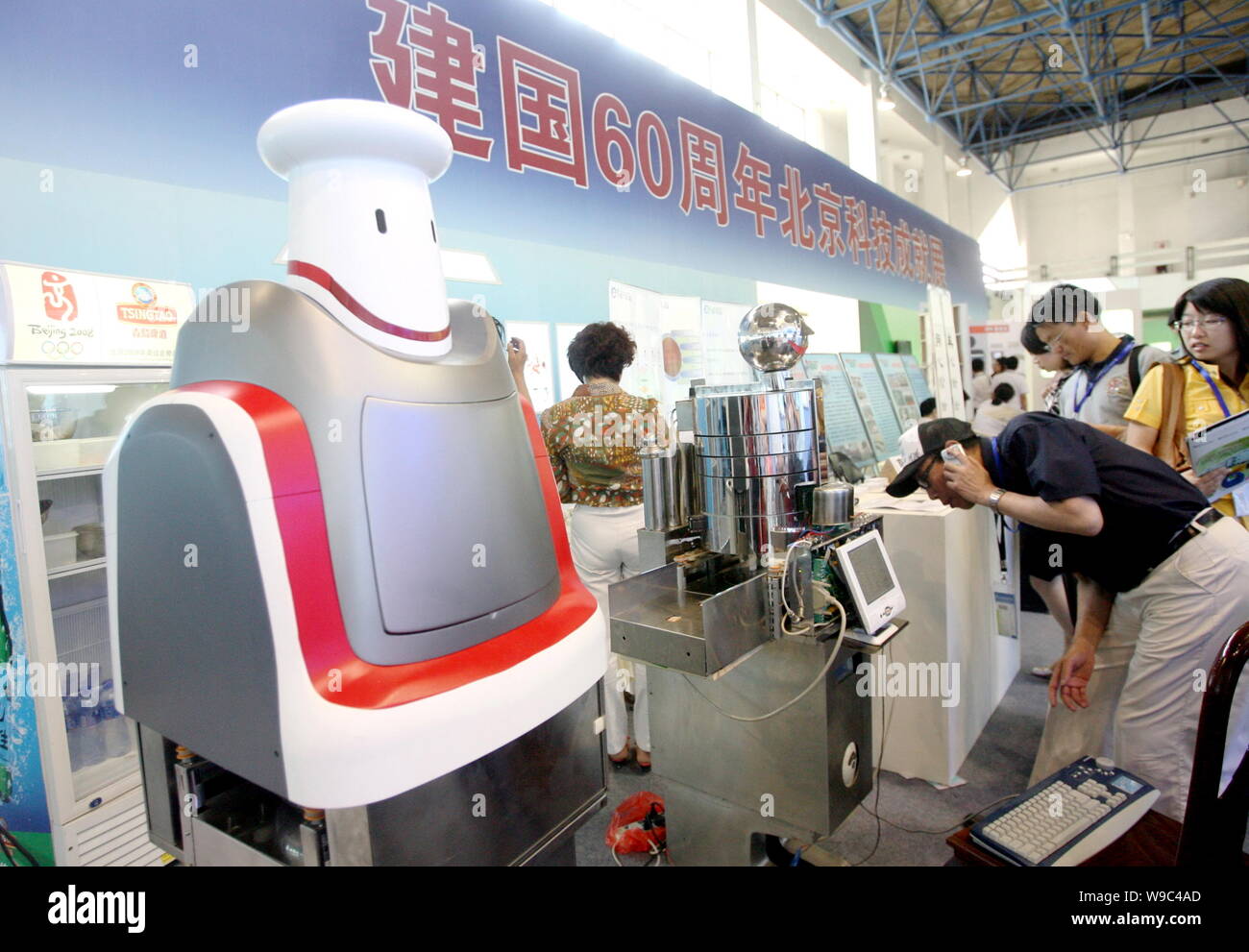 Visitors look at cooking robots on display at the 12th China (Beijing ...