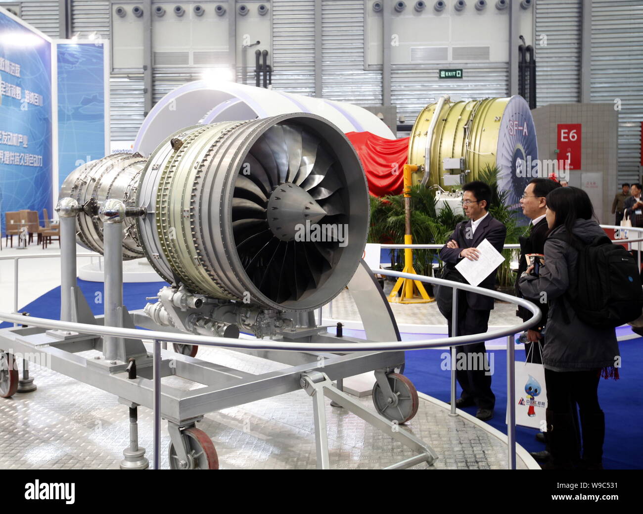 Visitors look at an aircraft enging at the stand of AVIC Commercial ...