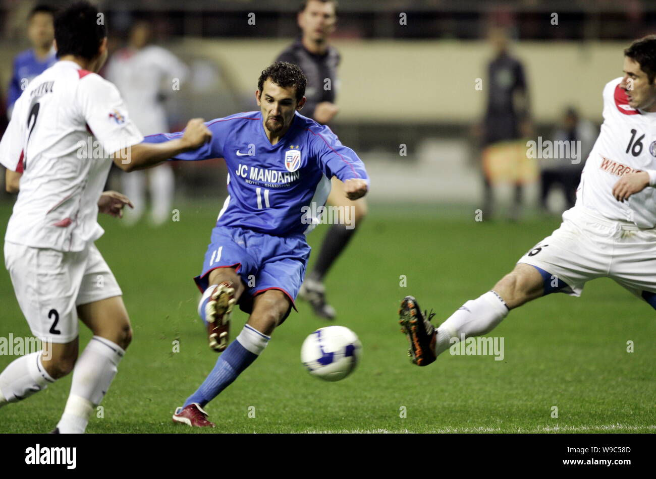 Hernan Barcos, center, of Shanghai Shenhua FC shoots amid Shaiful Esah ...