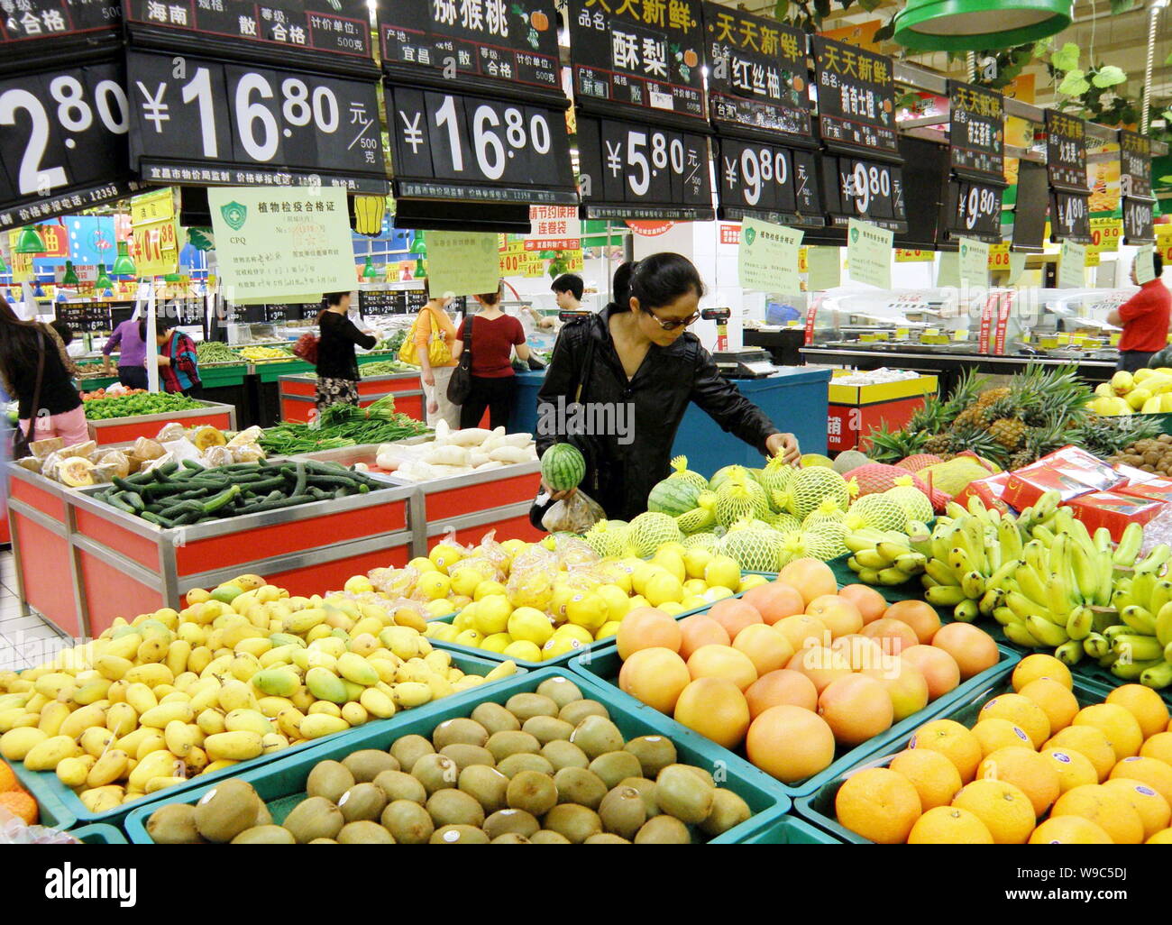 Chinese shoppers buy fruits and vegetables at a supermarket in Yichang ...