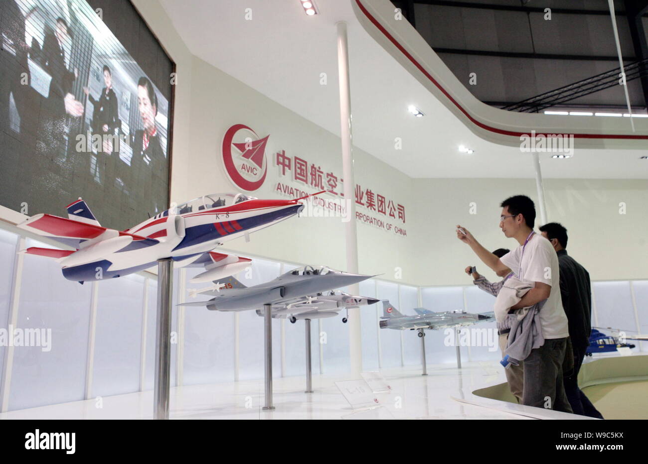 Visitors takes photos of plane models at the stand of Aviation Industry ...