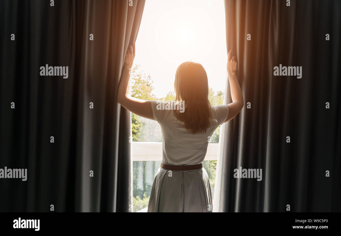 Woman opening curtains in the hotel room at sunny morning Stock Photo ...