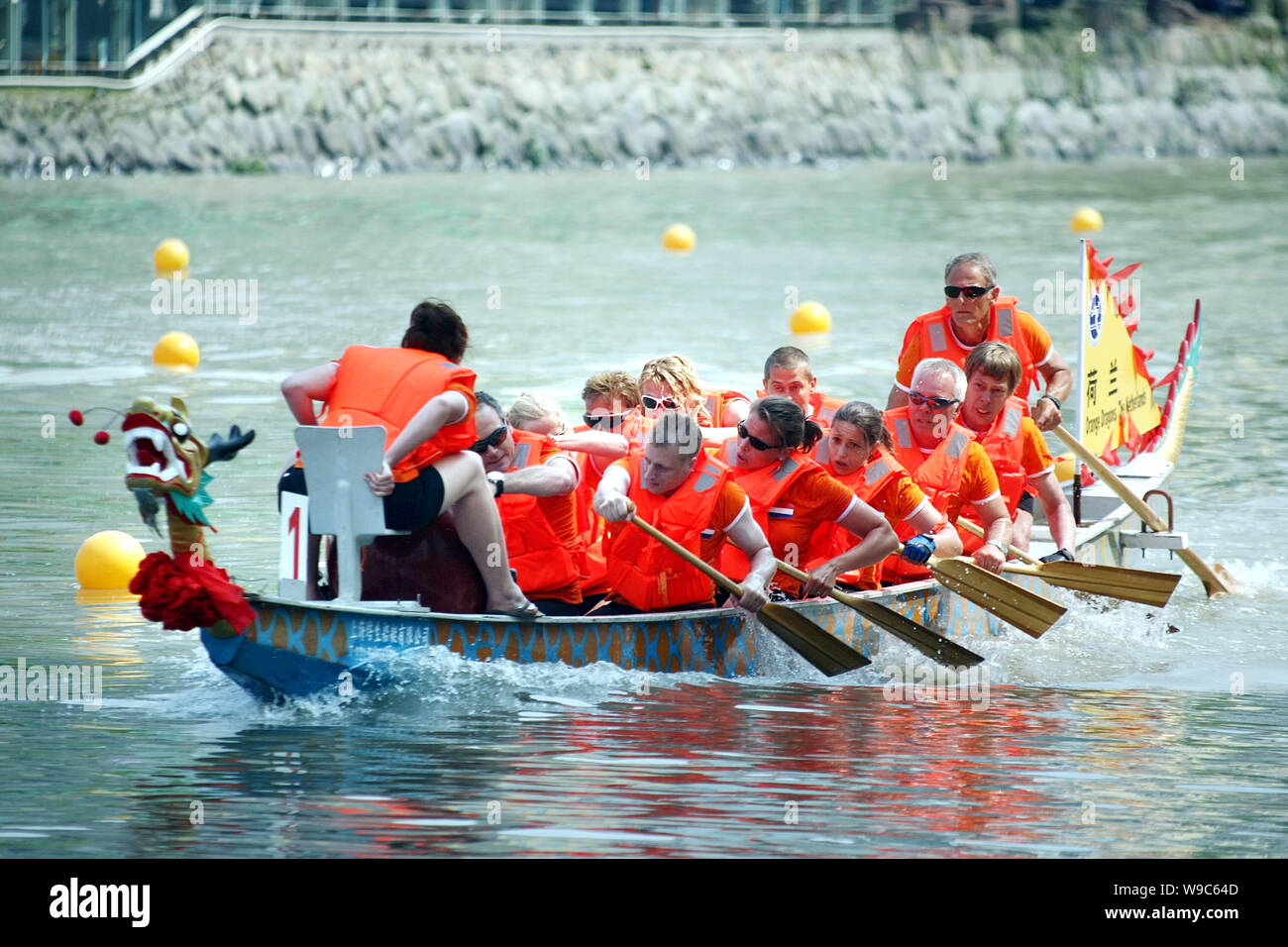 Foreign participants compete during a dragon boat contest to celebrate ...