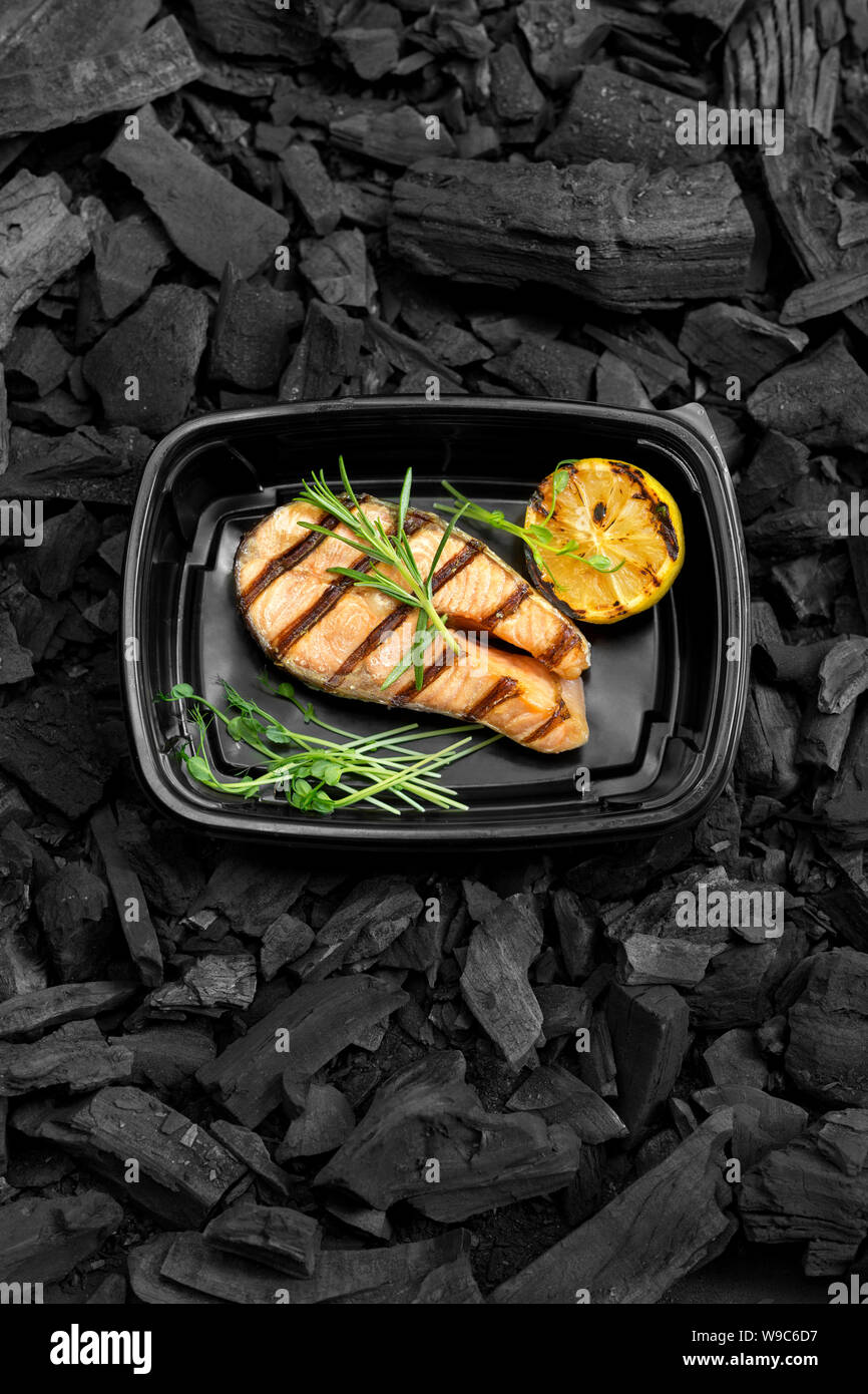 Freshly cooked grill red fish in black delivery box on coal Stock Photo ...