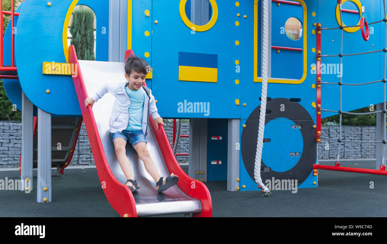 Happy smiling child on playground. Happy kids playing outdoors, clear ...