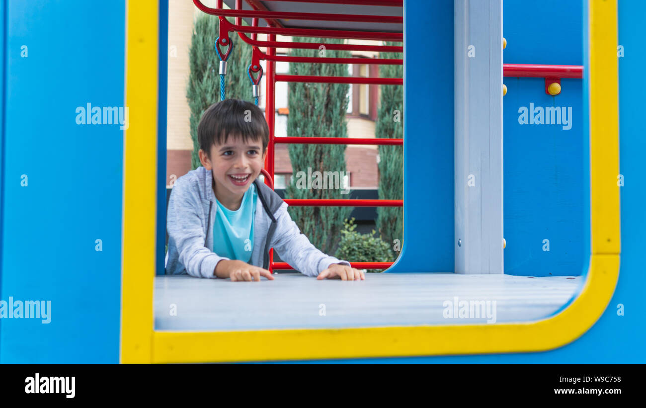 Happy smiling child on playground. Happy kids playing outdoors, clear ...