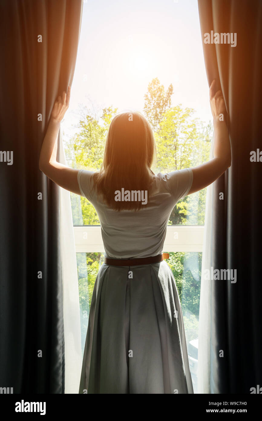 Woman opening curtains in the hotel room at sunny morning Stock Photo ...