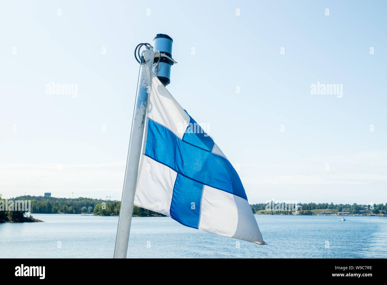 A finnish flag on a boat in the wind on lake Saimaa near the ...