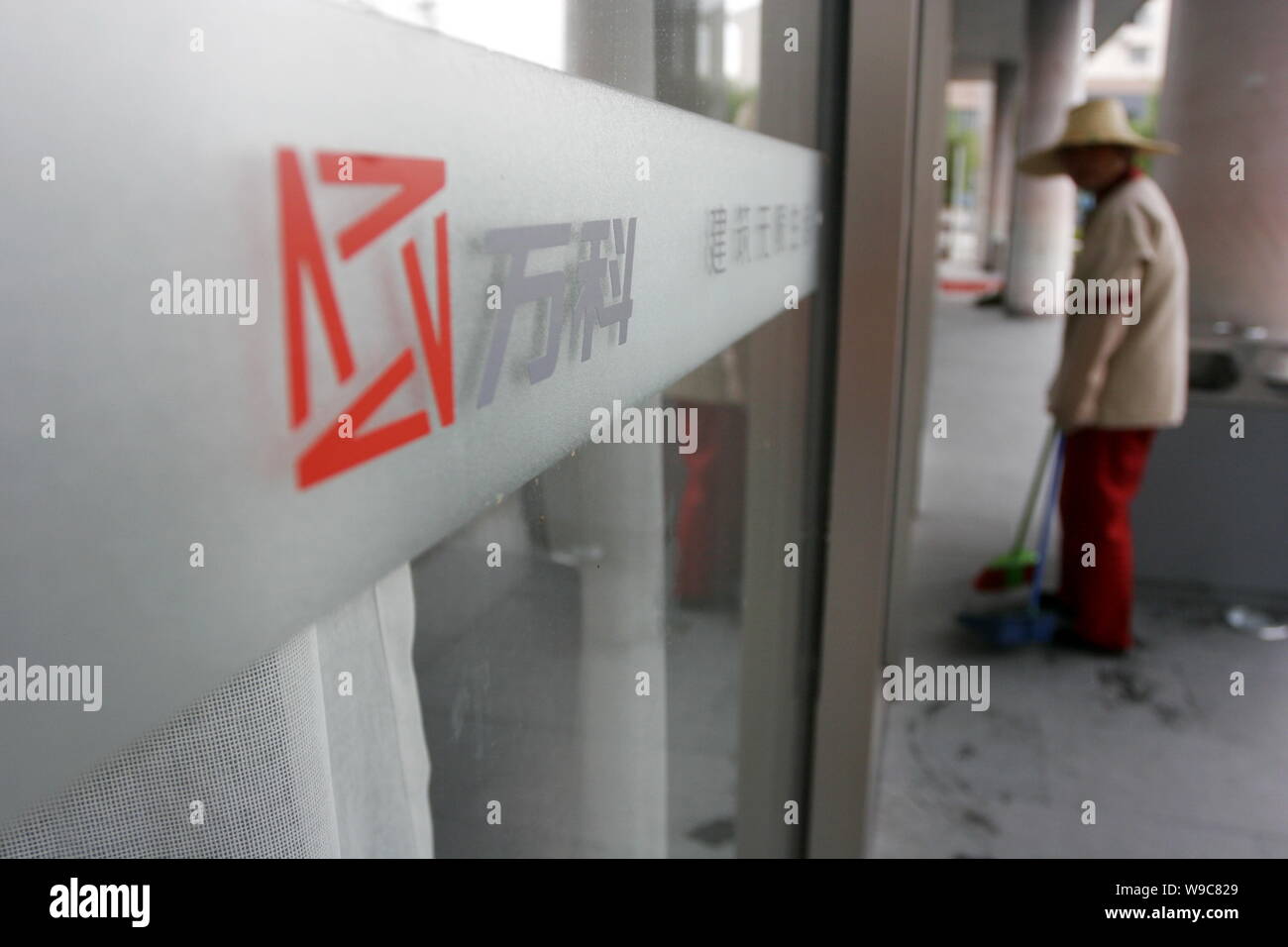 --FILE--A Chinese worker cleans the street in front of the sales center ...
