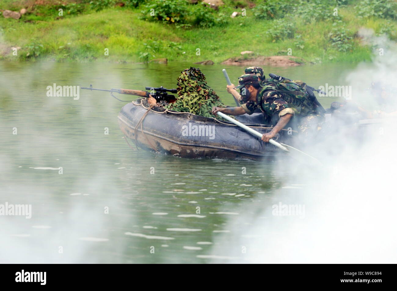 Chinese PLA (Peoples Liberation Army) soldiers row a boat to cross a ...