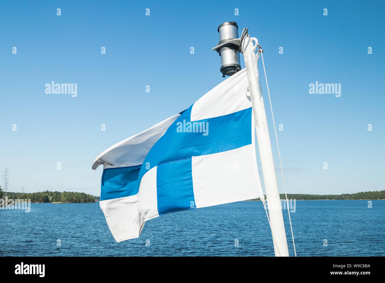 A finnish flag on a boat in the wind on lake Saimaa near the ...