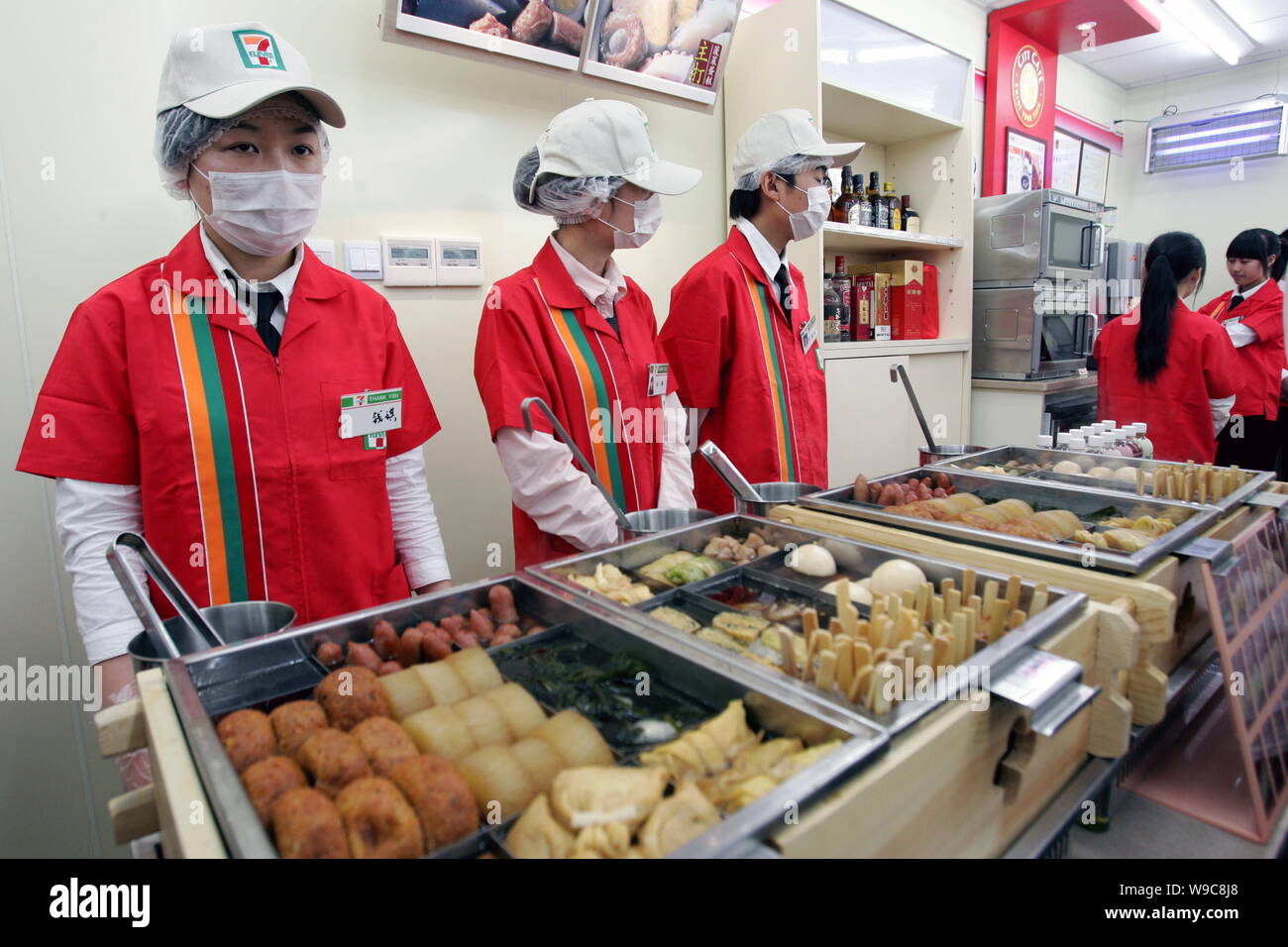 --FILE-- Chinese employees wait for customers at a 7-Eleven convenience ...