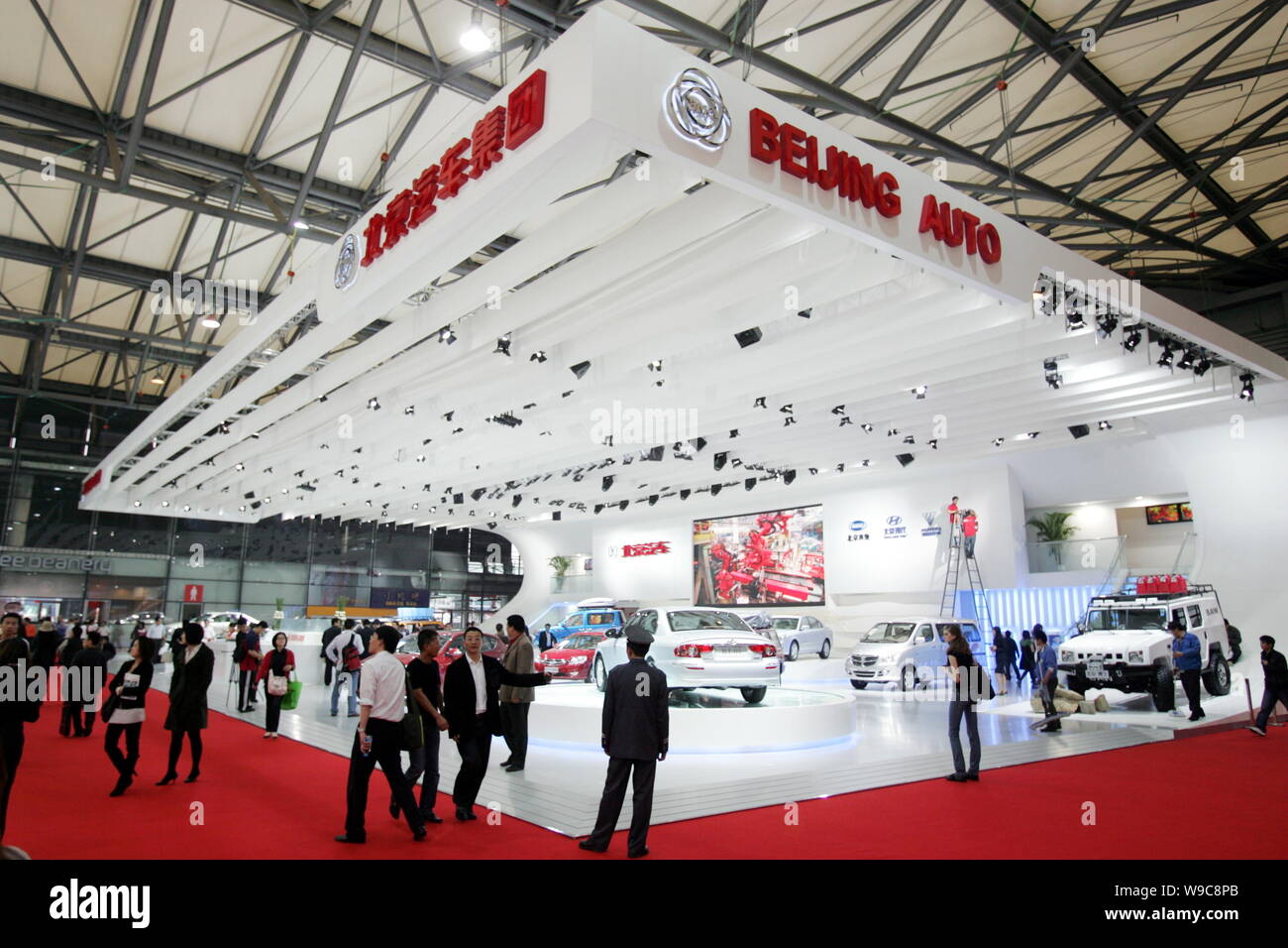 --FILE--Visitors look at cars at the stand of BAIC (Beijing Automotive ...