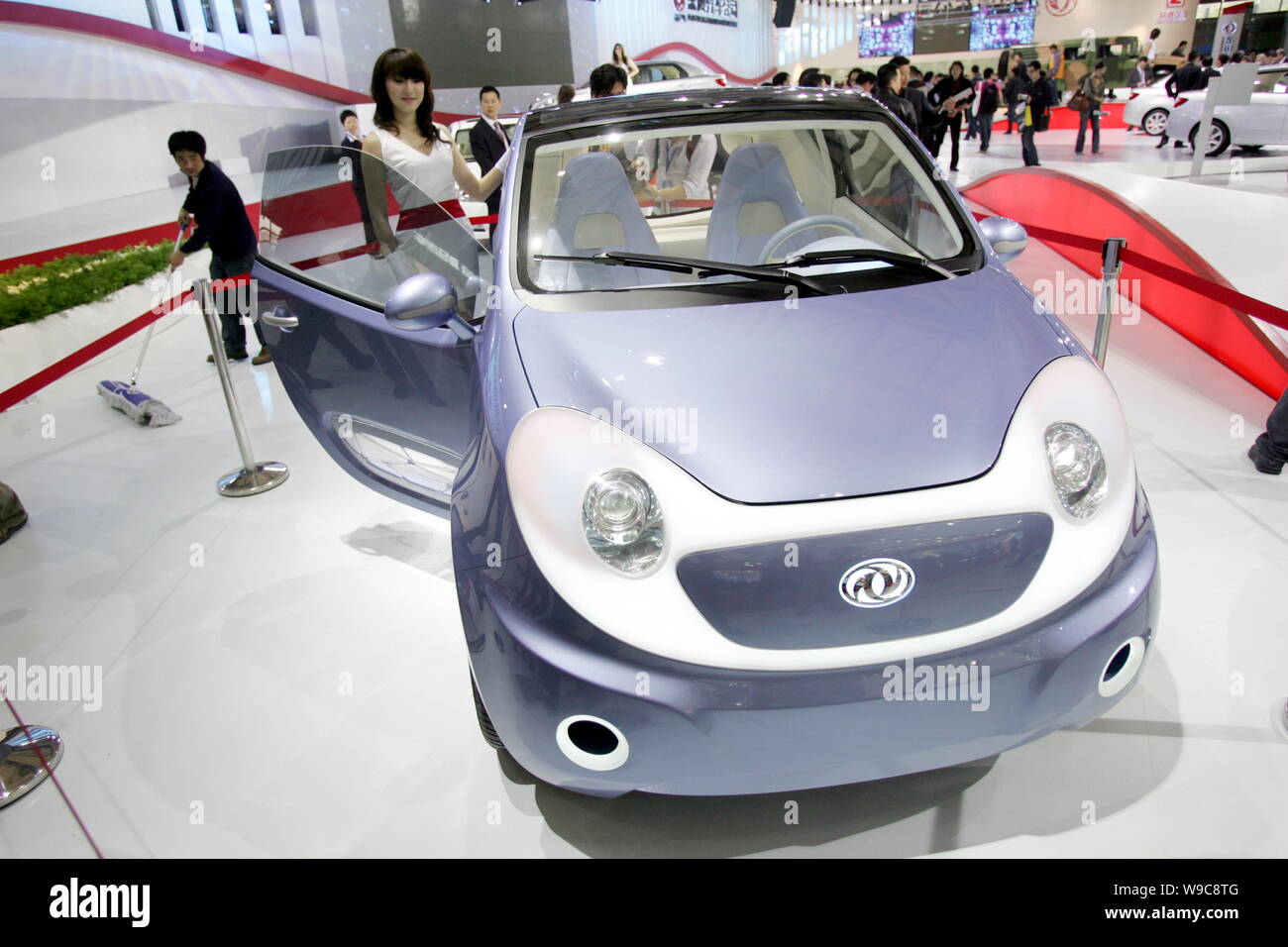 A model poses with a Dongfeng I-Car electric car at the 13th Shanghai ...