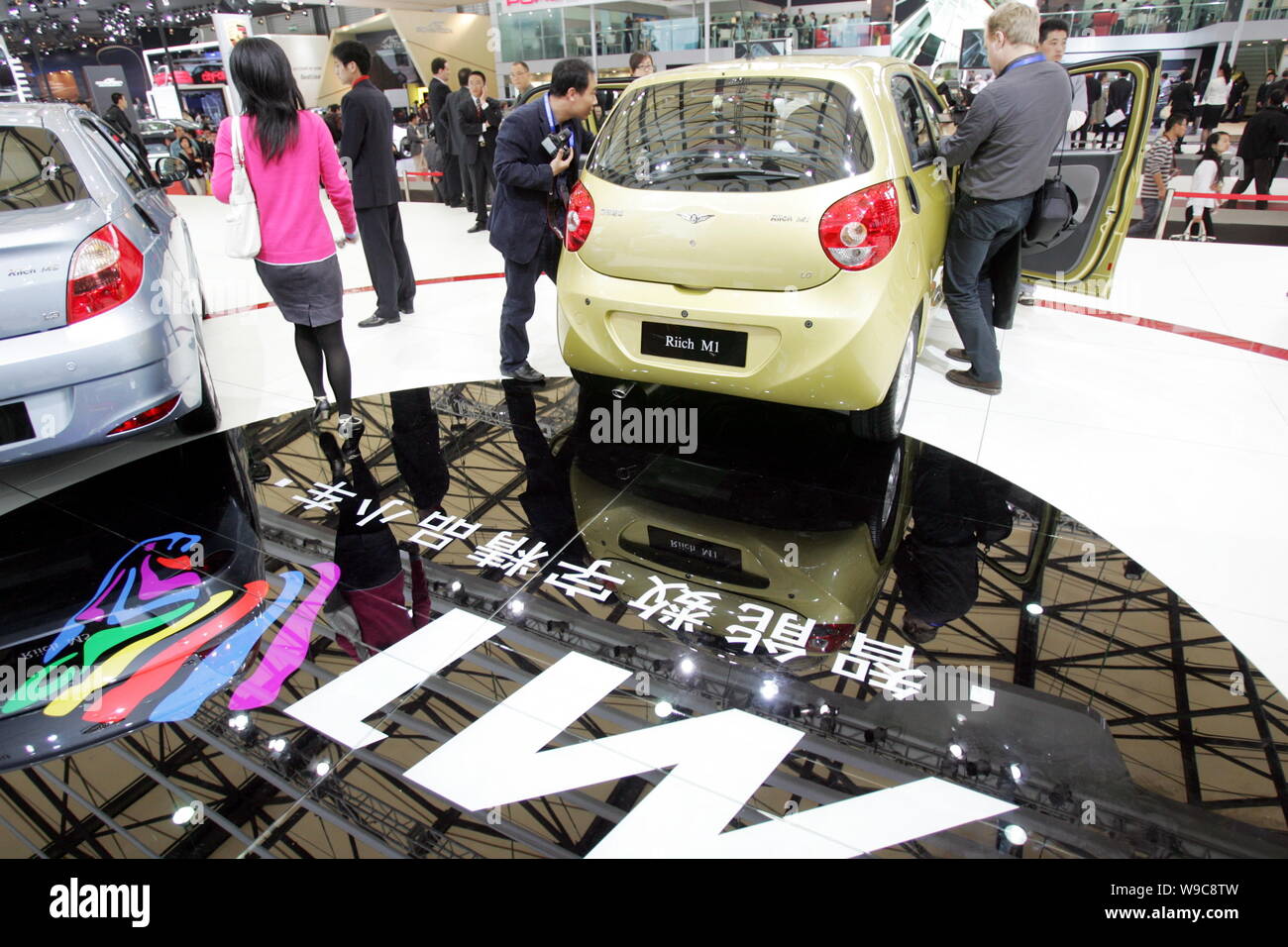 Visitors look at a Chery Riich M1 at the 13th Shanghai International ...