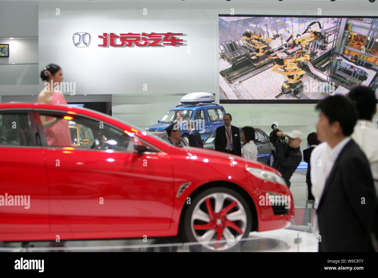 --FILE--Visitors look at cars at the stand of BAIC (Beijing Automotive ...
