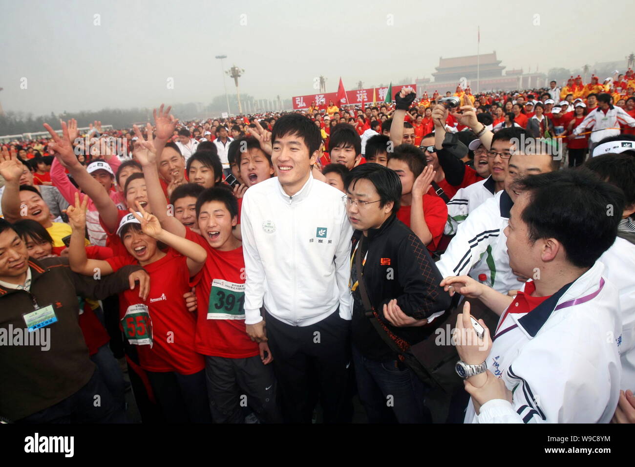 Chinese star hurdler Liu Xiang, middle, is seen surrounded by ...
