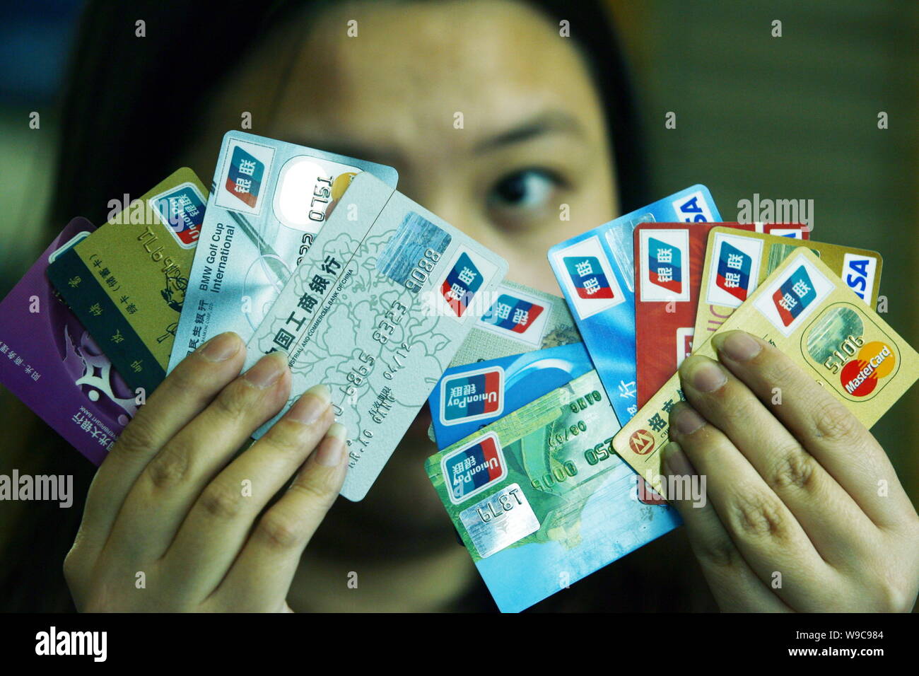 --FILE--A Chinese woman shows credit cards with the logos of China ...