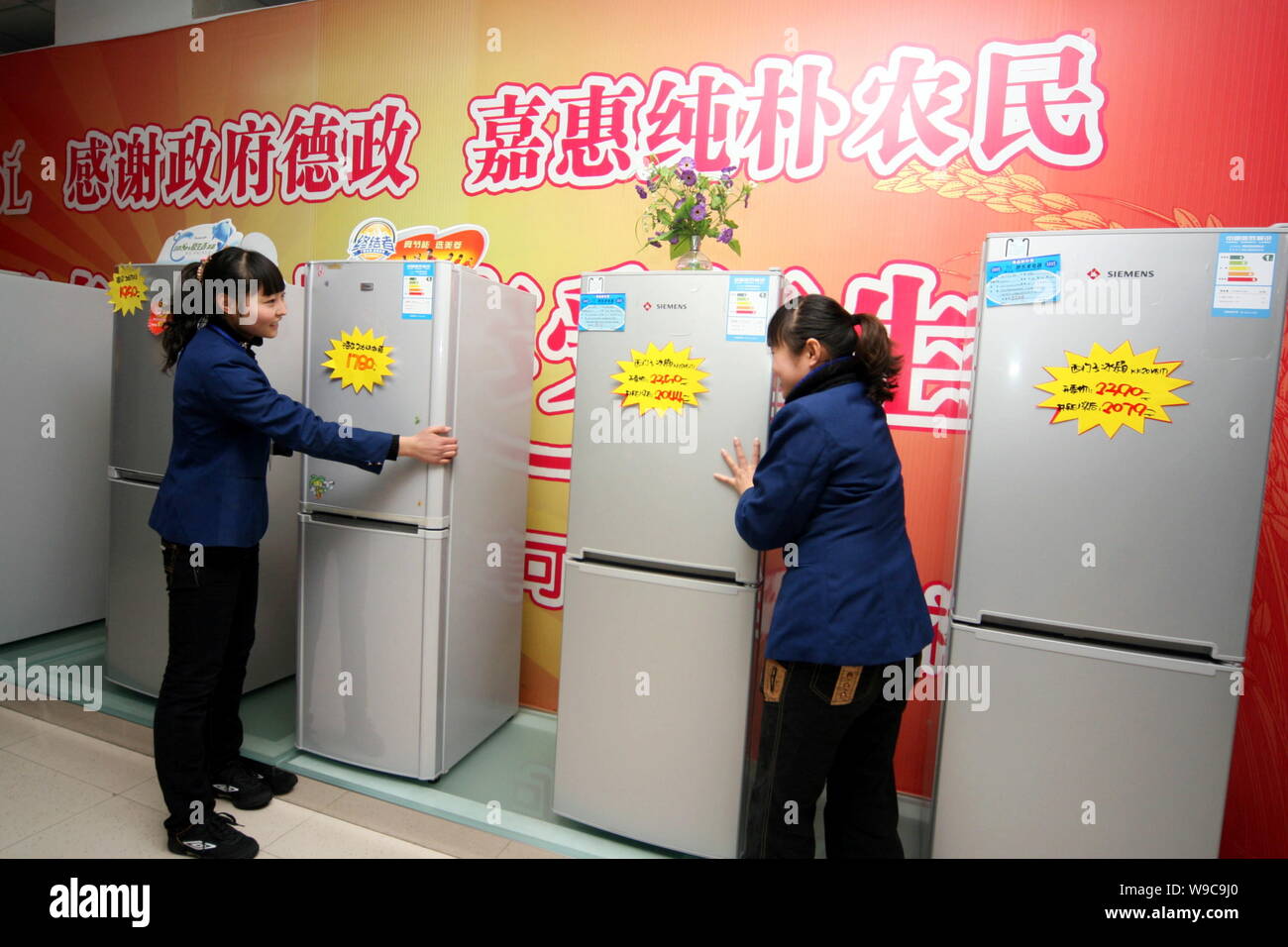 Chinese saleswomen adjust refrigerators benefitting from a government ...