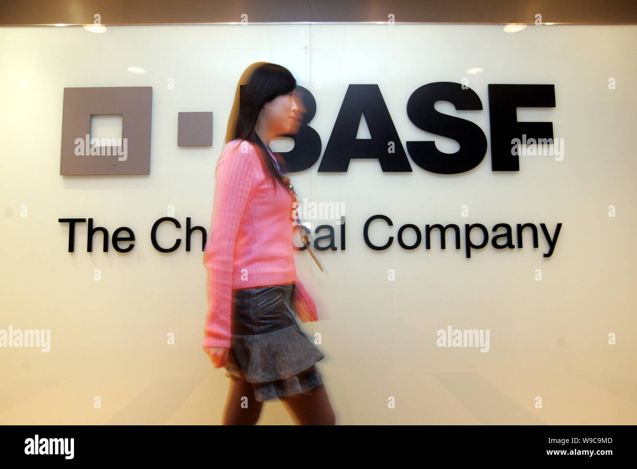 --FILE--A Chinese employee walks past the logo of BASF at the BASF ...