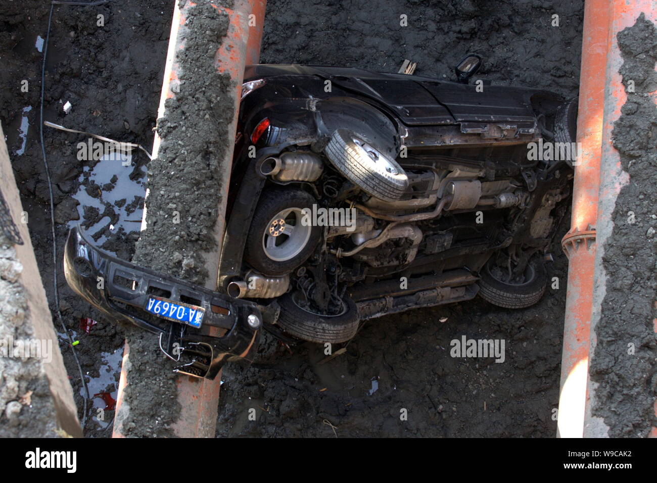 A car is seen crashed in a pit at a subway construction site in ...