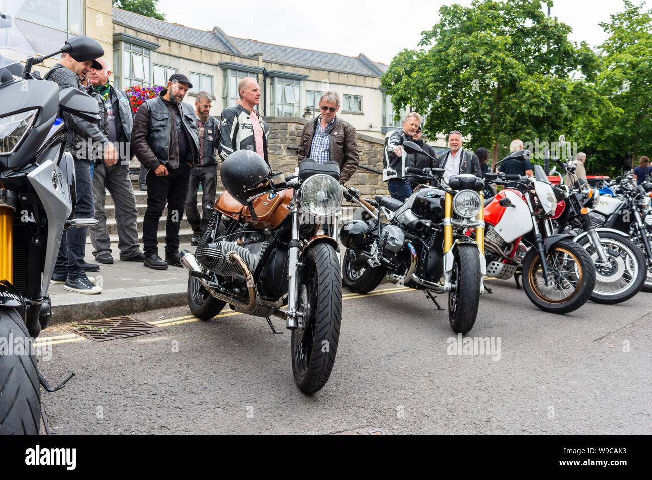 Visitors admiring and discussing bikes, including a BMW cafe racer ...