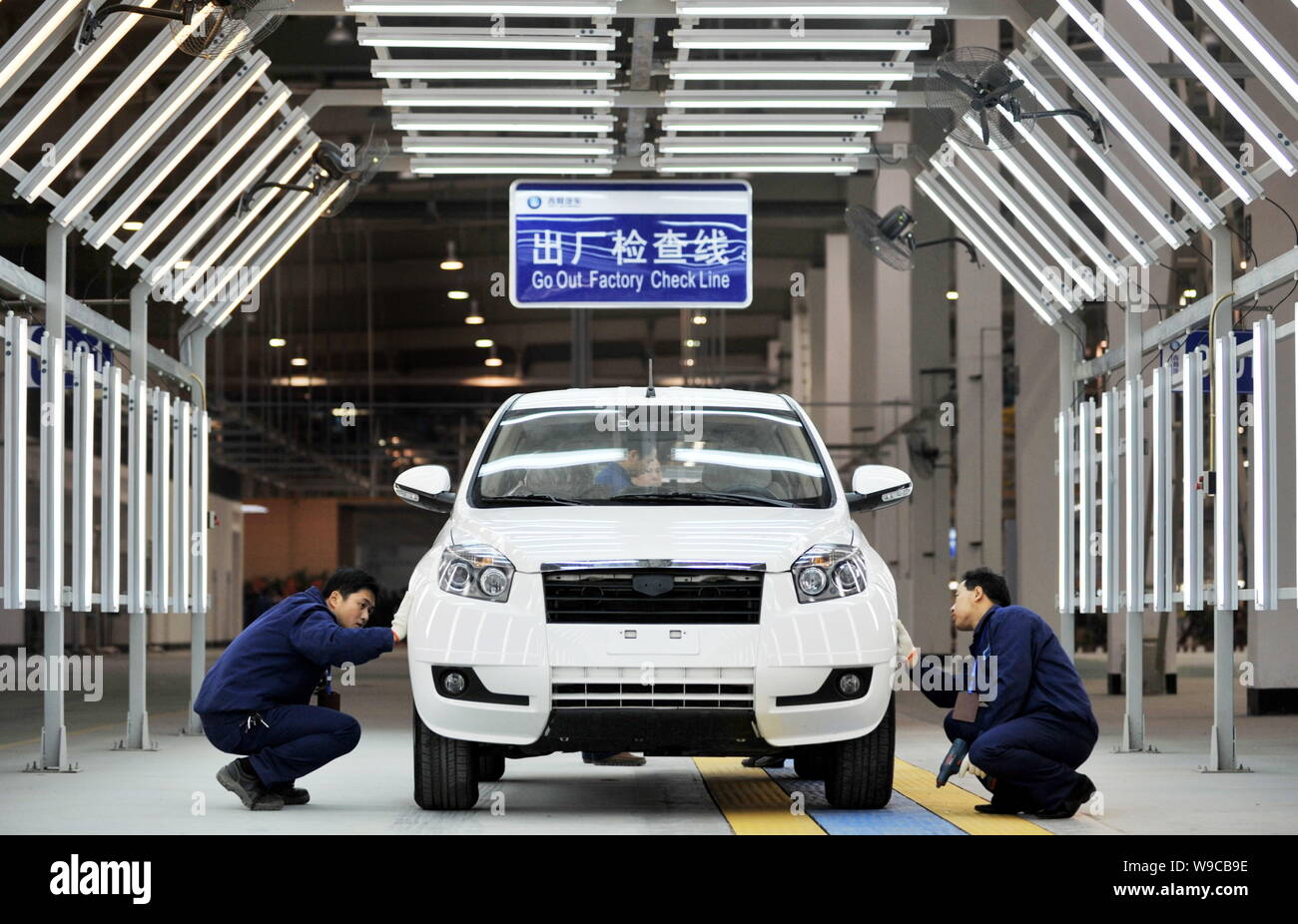 Chinese factory workers check a Geely Gleagle SUV at the Geely auto ...