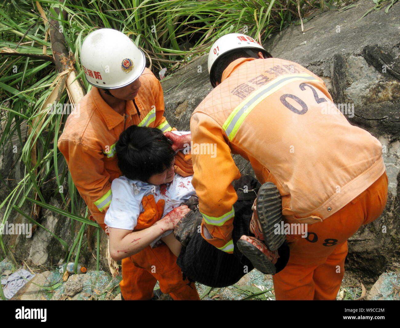 Chinese rescuers take a passenger who was injured in a bus overturn to ...