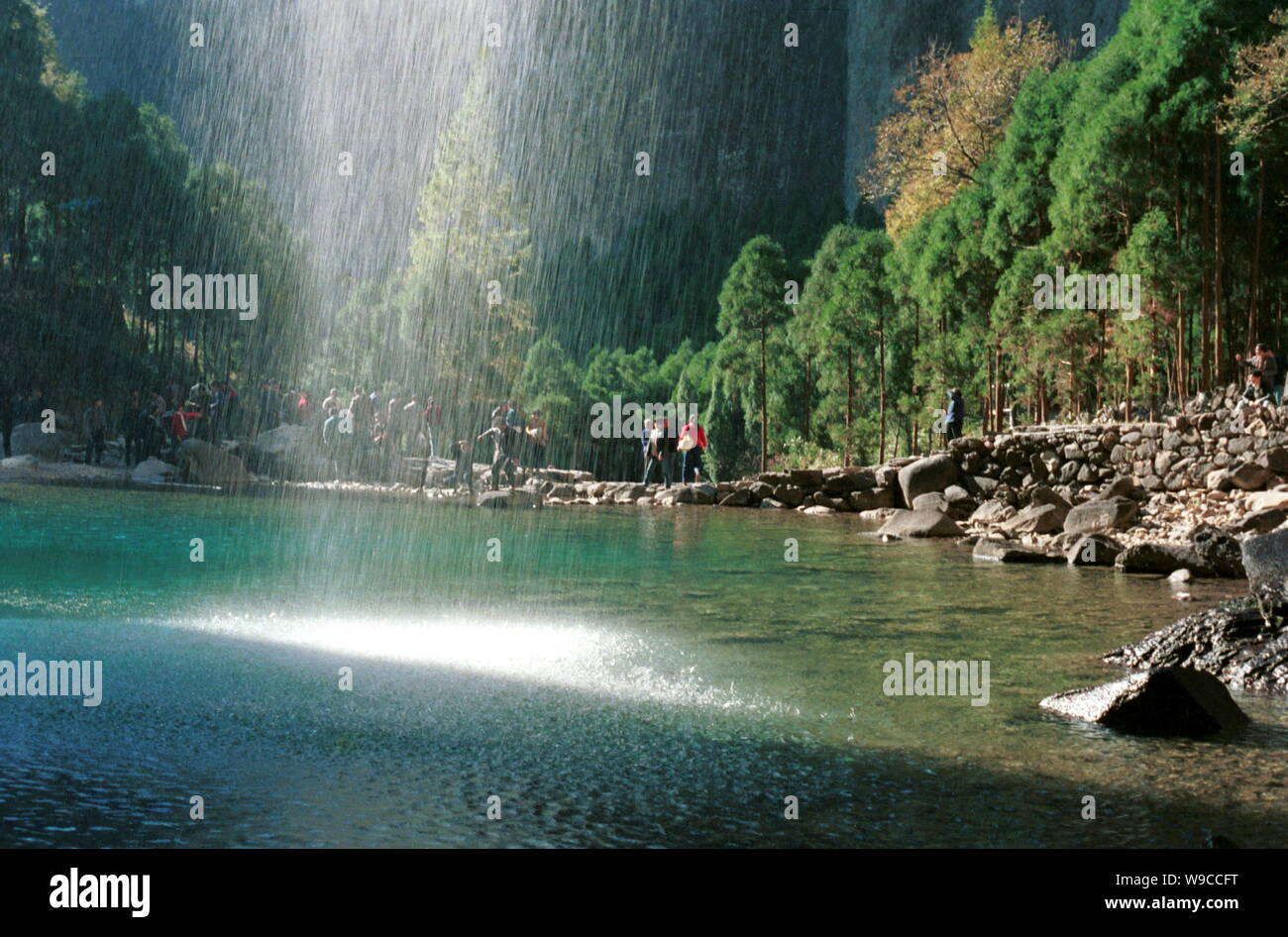 Tourists look at a waterfall in the Yandang Mountain senic spot in ...