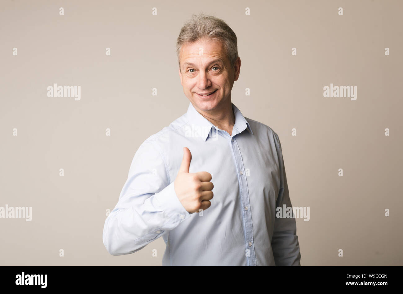 Happy man showing thumbing up and smiling Stock Photo - Alamy
