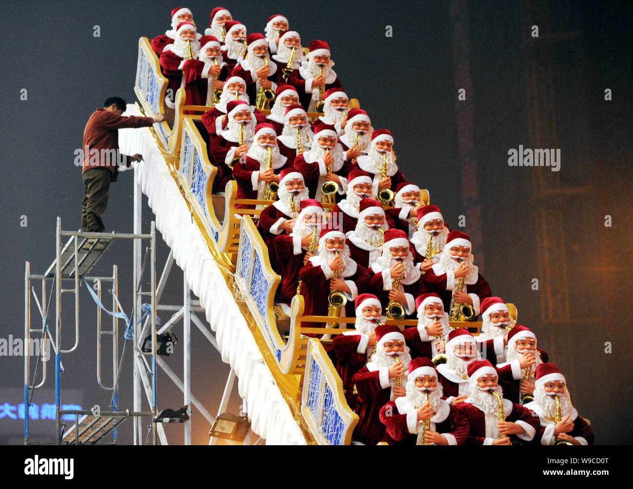 A Chinese worker sets up a model roller coaster with model Santa ...