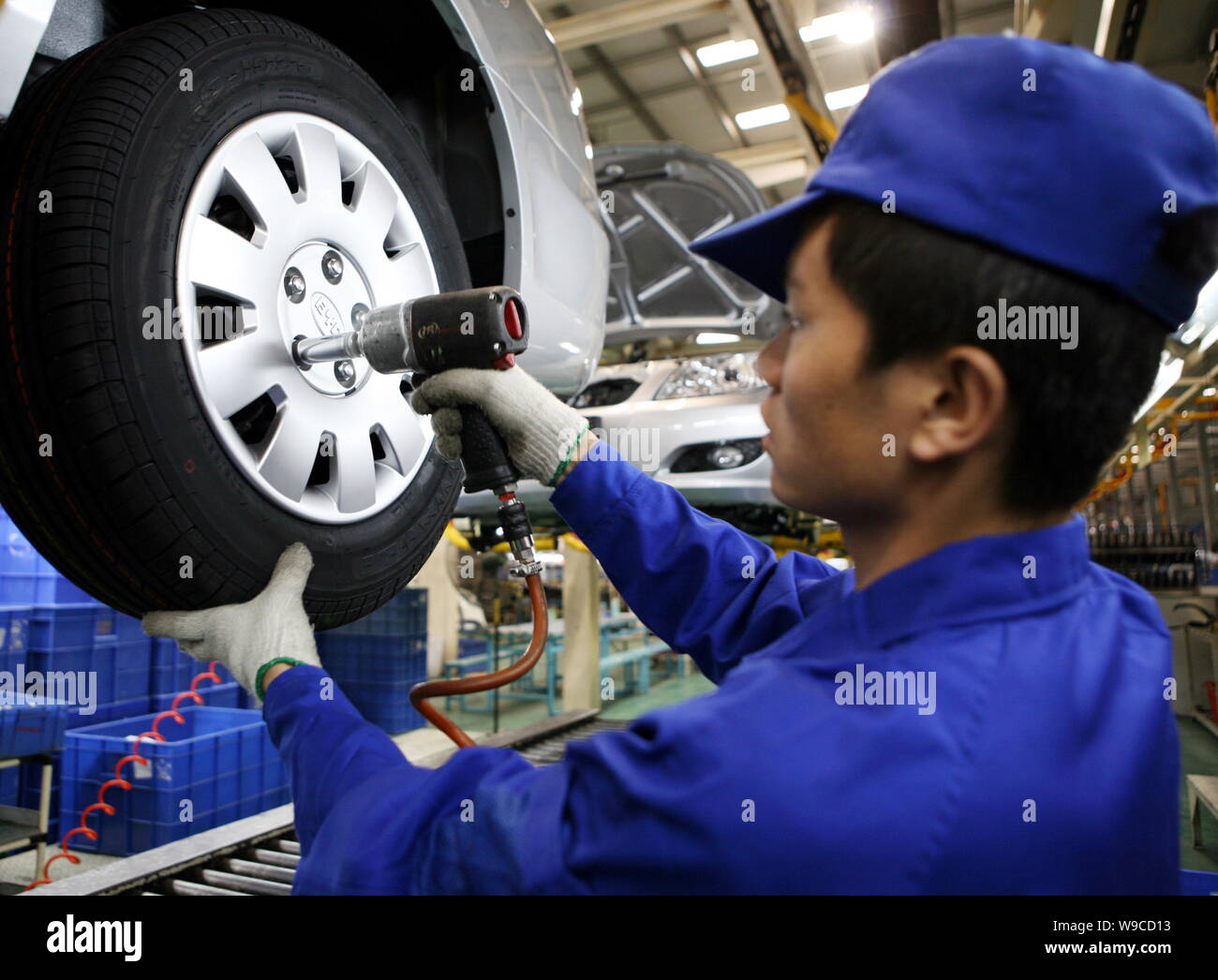 A Chinese factory worker assembles a BYD car on the production line at ...