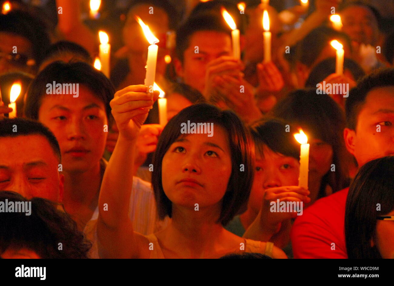 --FILE--Local Chinese citizens hold up ignited candles to pray for the ...