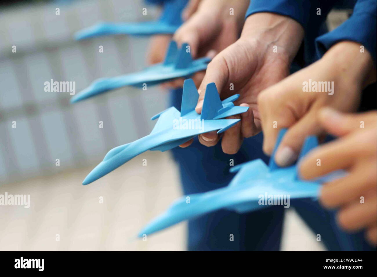 Chinese PLA Air Force pilots holding model fighter planes practise ...